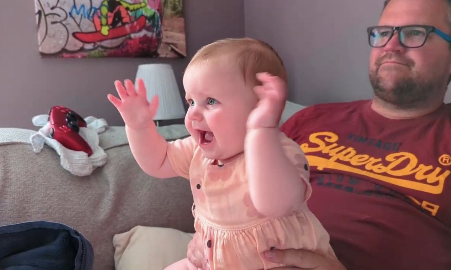 An amusing moment! Baby Lily enjoys Glastonbury, playing the air drums ...